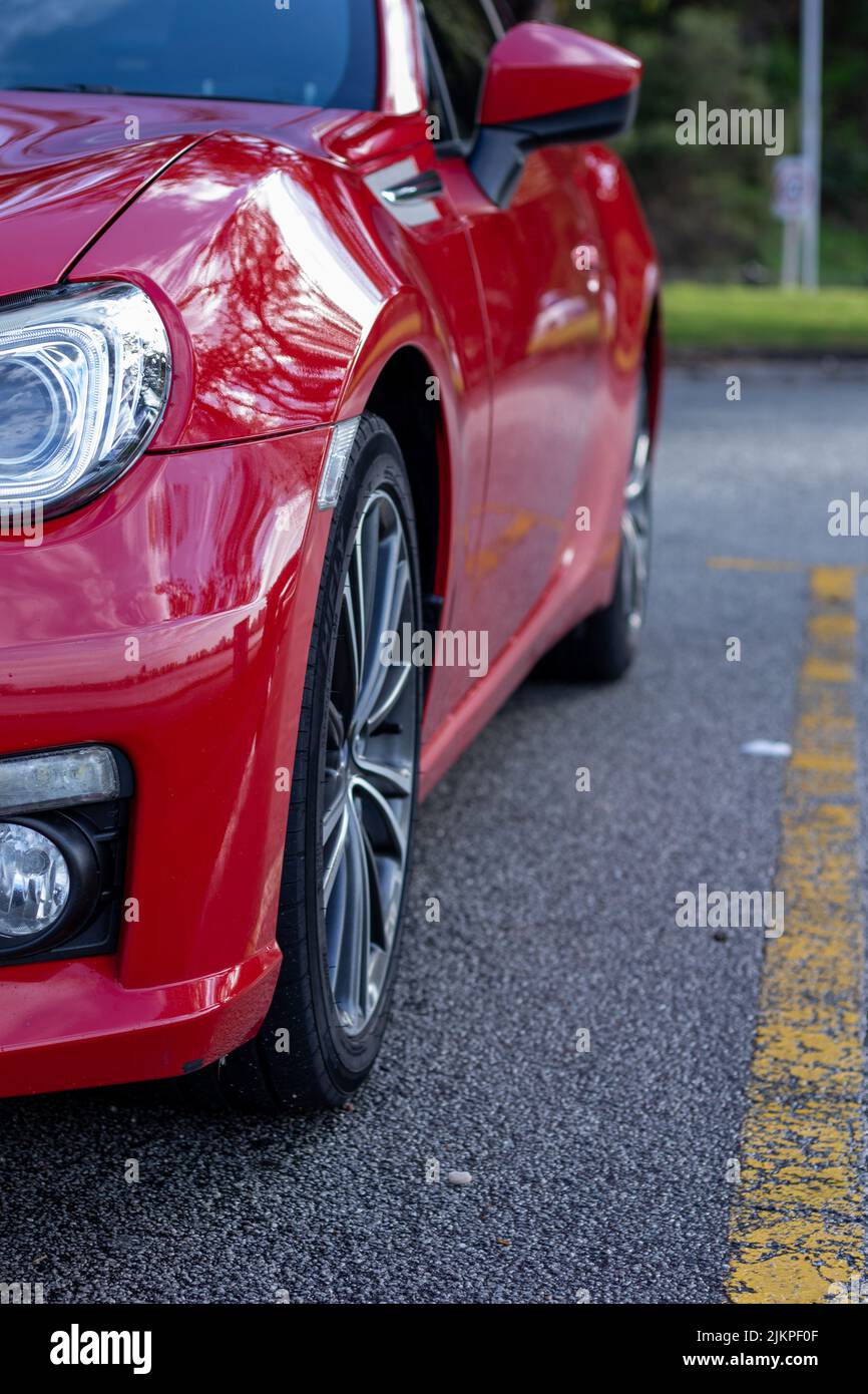 A vertical shot of a red sports car parked on a street Stock Photo - Alamy