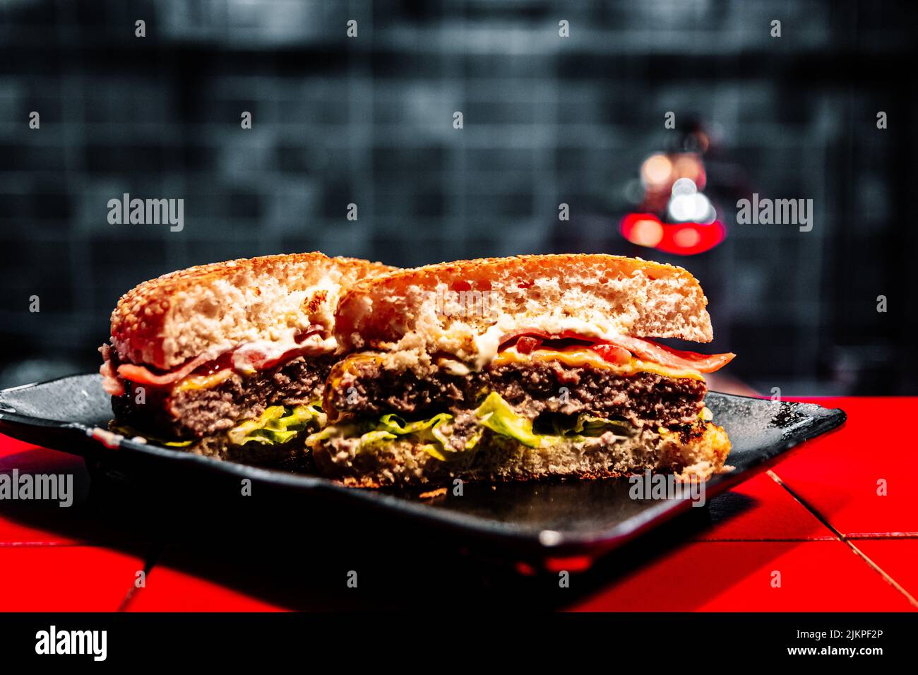 A close-up shot of a cut burger on a plate with copy space Stock Photo ...