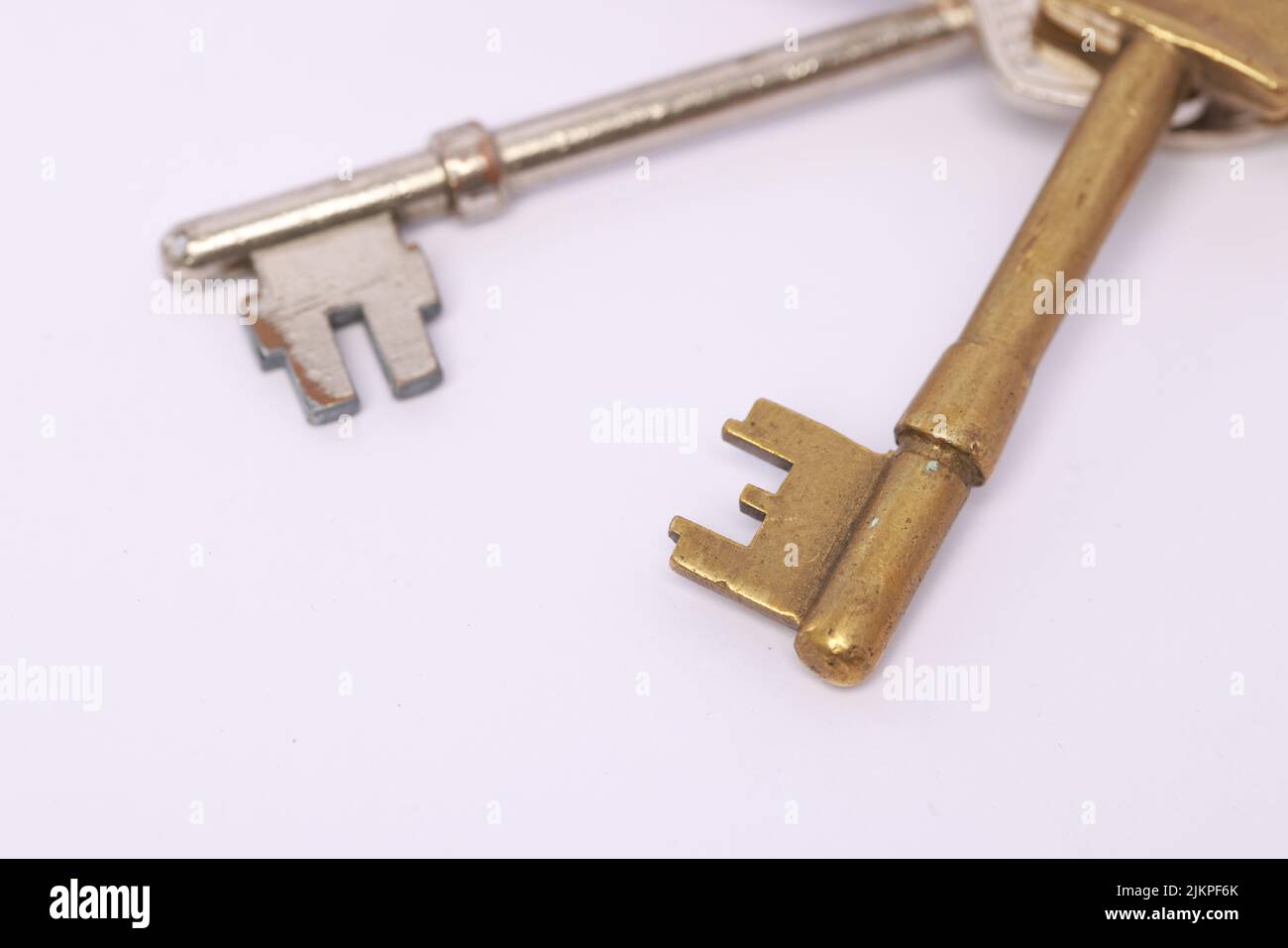 A closeup of a stack of keys isolated on a white background with ...