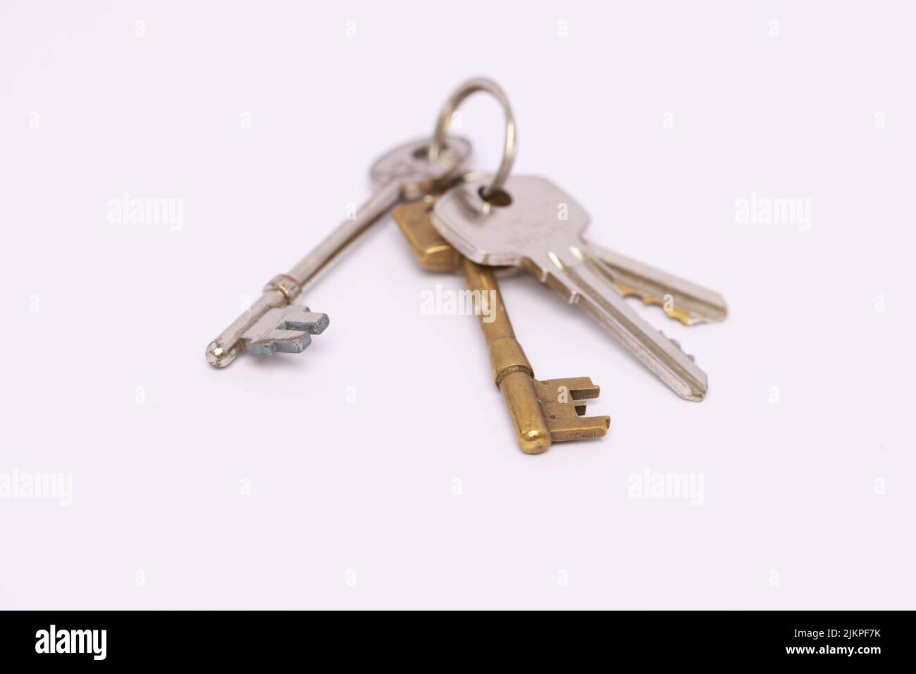 A closeup of a stack of keys isolated on a white background with ...
