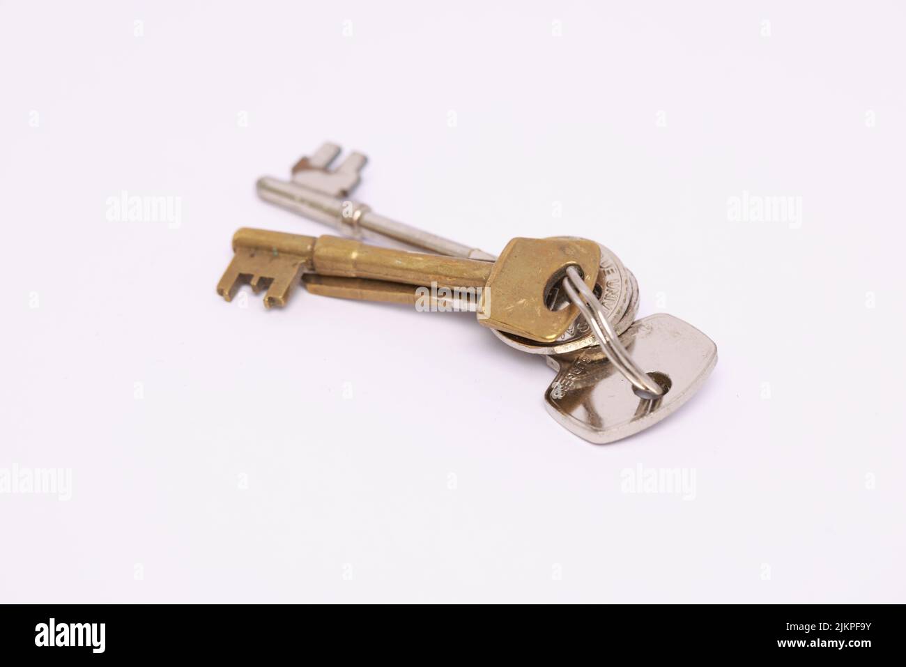 A closeup of a stack of keys isolated on a white background with ...