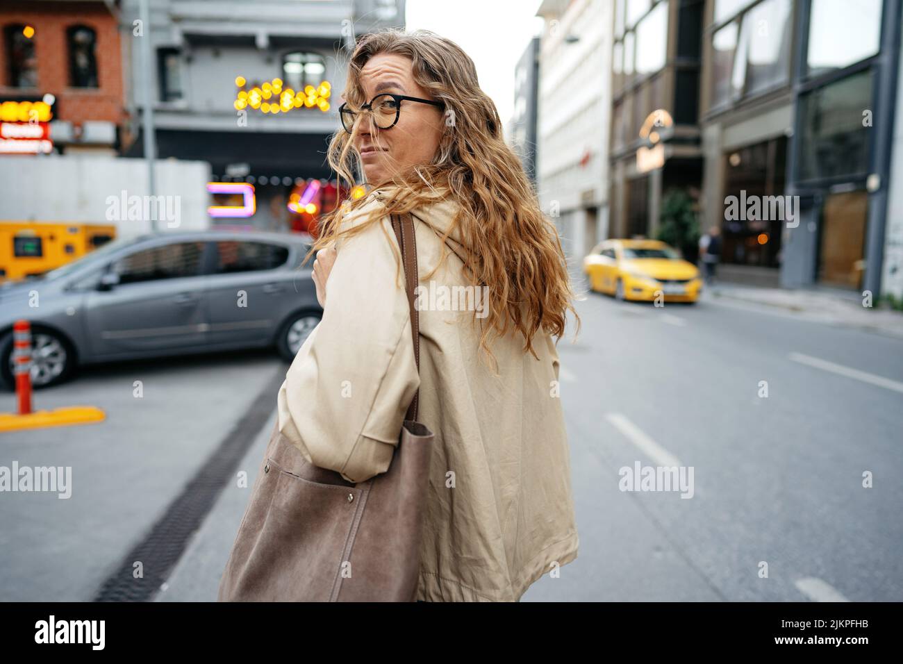 Young beautiful pretty woman walking along the street in modern city ...
