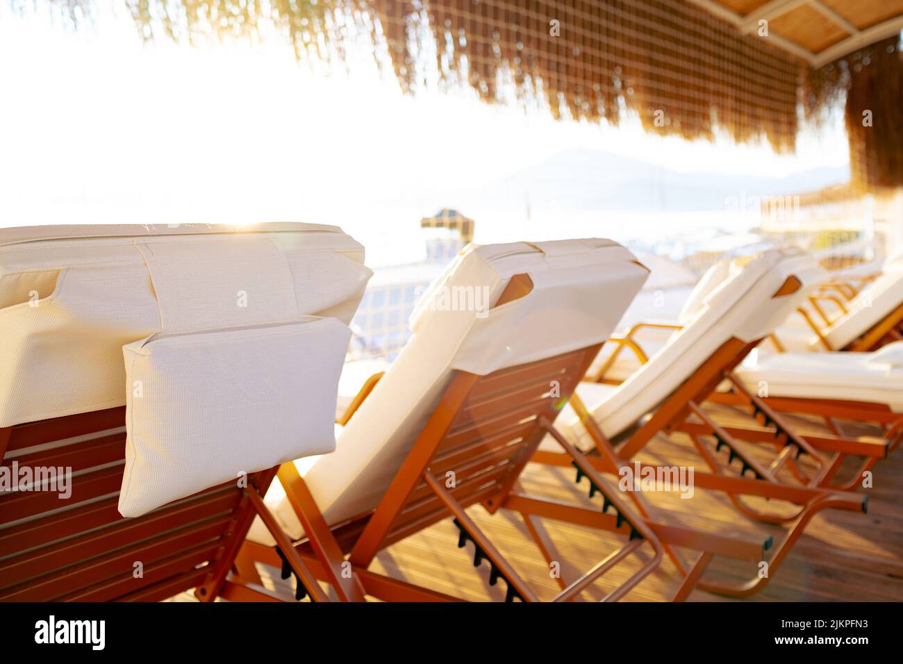 Empty deck chairs with white mattresses in resort hotel Stock Photo - Alamy