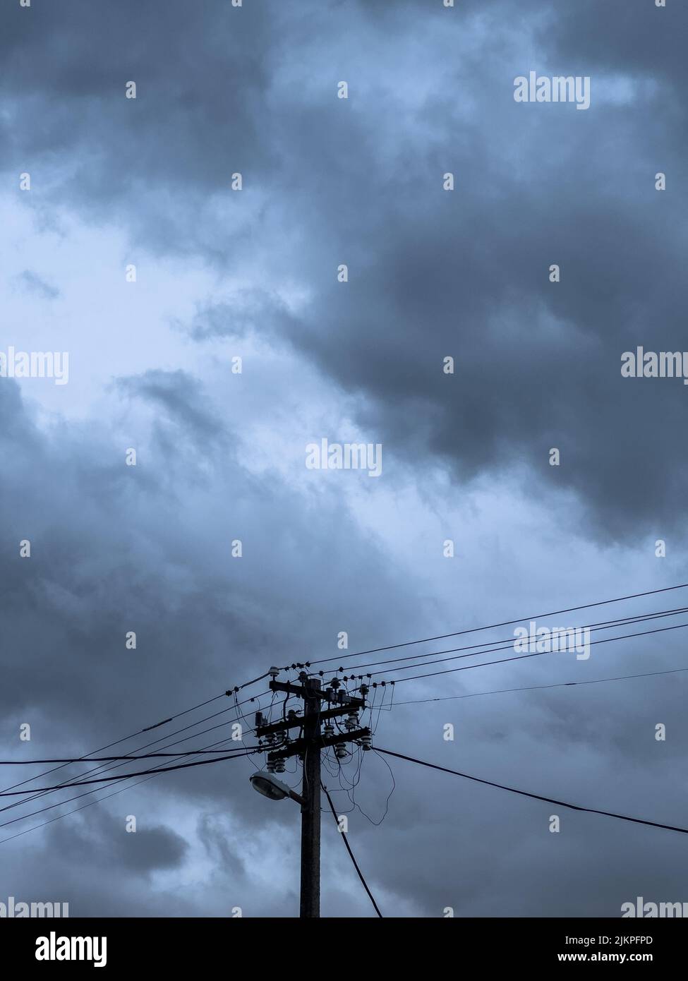 a low angle shot of electro lines agaisnt dark sky Stock Photo - Alamy