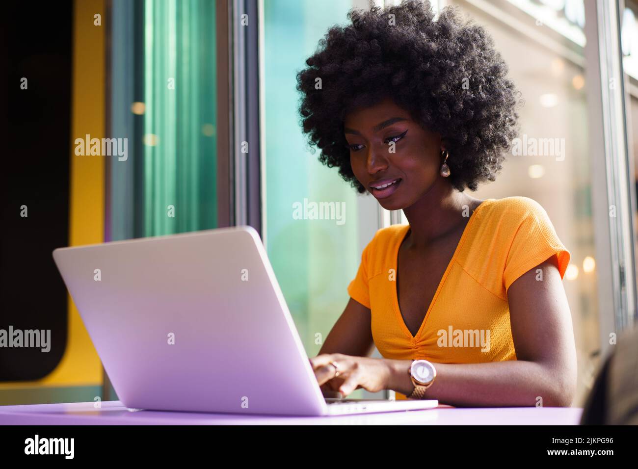 Happy beautiful young black woman using laptop in cafe Stock Photo - Alamy