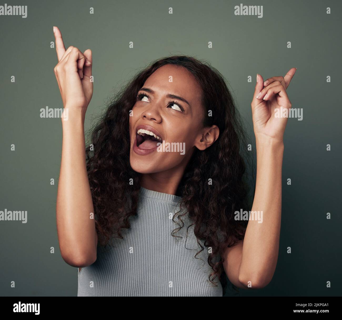 Which ones got your attention. Studio shot of an young woman pointing ...