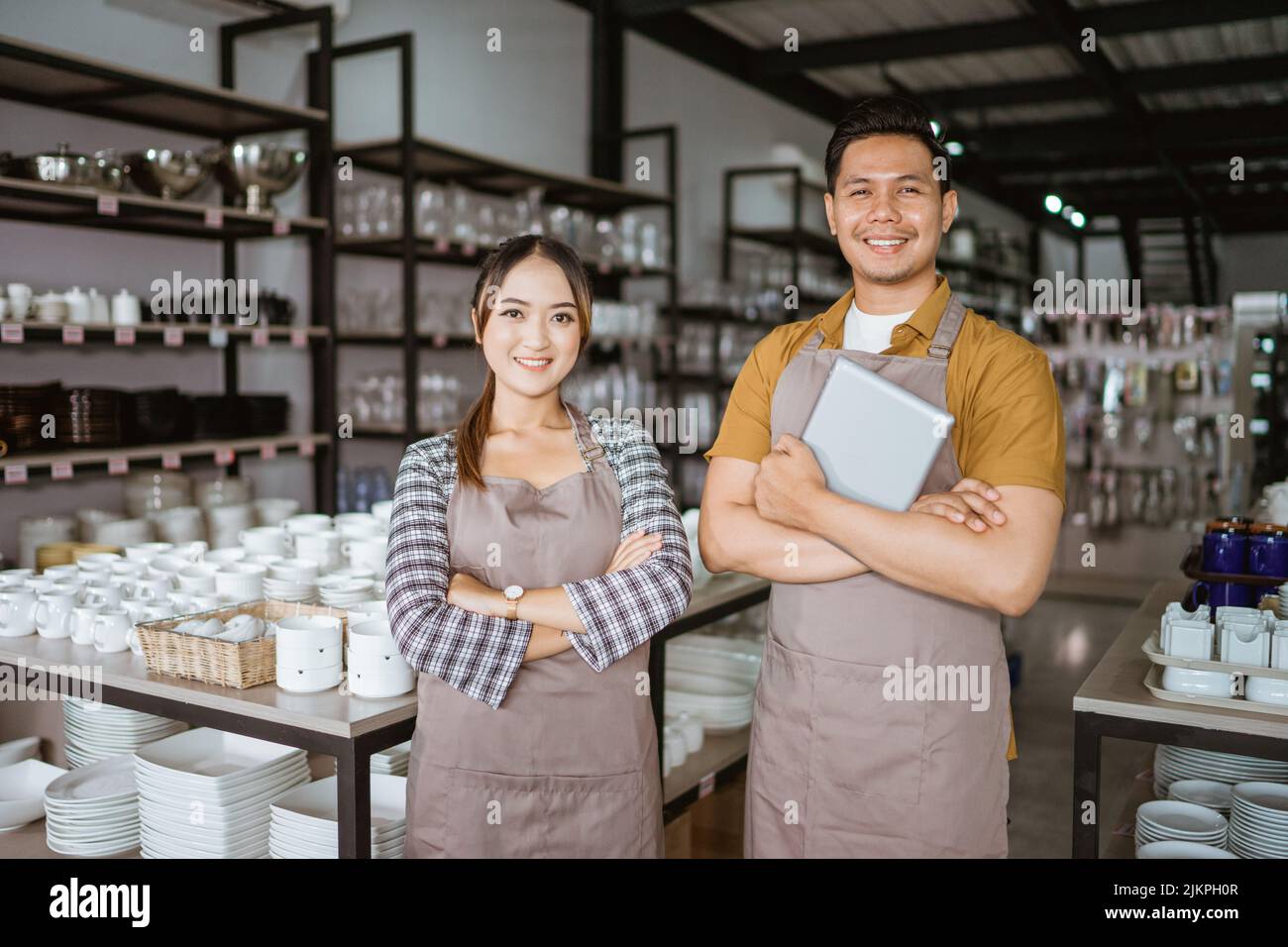 Two shop owners holding digital tablet with hands crossed Stock Photo ...