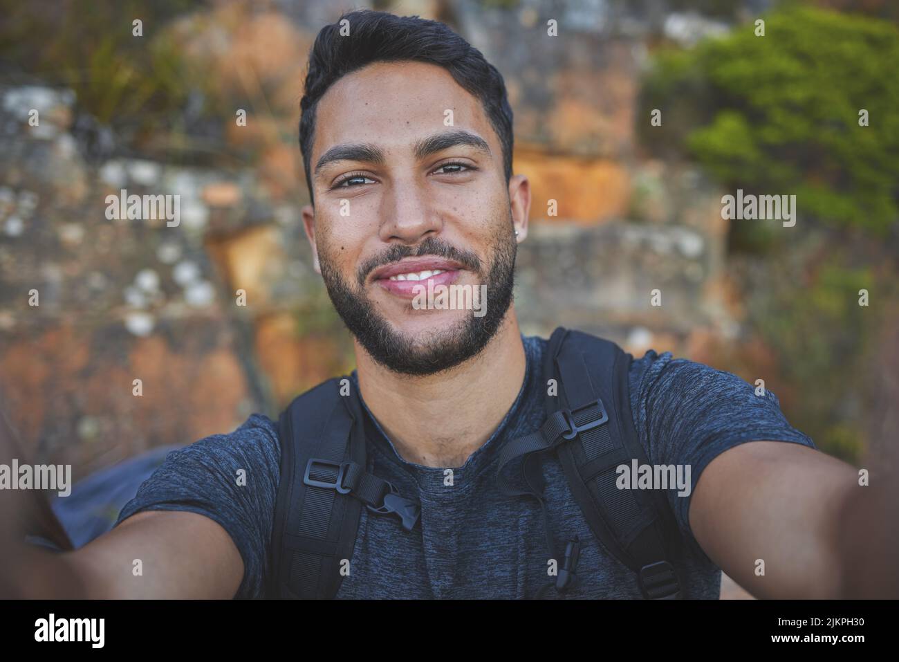 I love taking photos outdoors. a young man taking a break while hiking ...