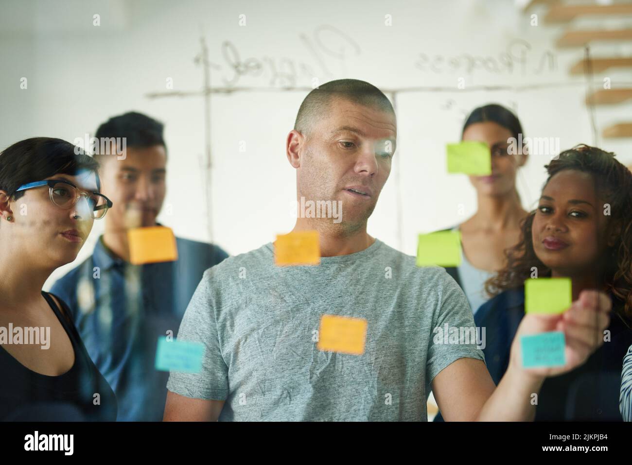 Teamwork, planning and writing on sticky notes while brainstorming ...