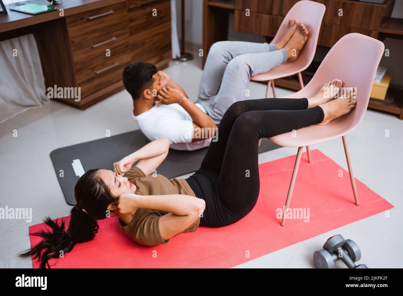 beautiful woman and husband doing sit up together using chair Stock ...