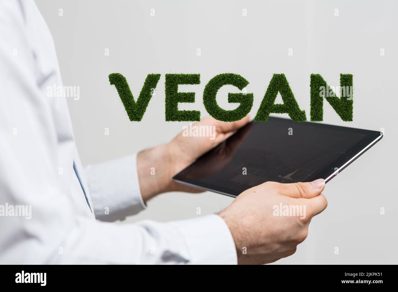 A dark green vegan text hovering on a man's tablet - Organic production ...
