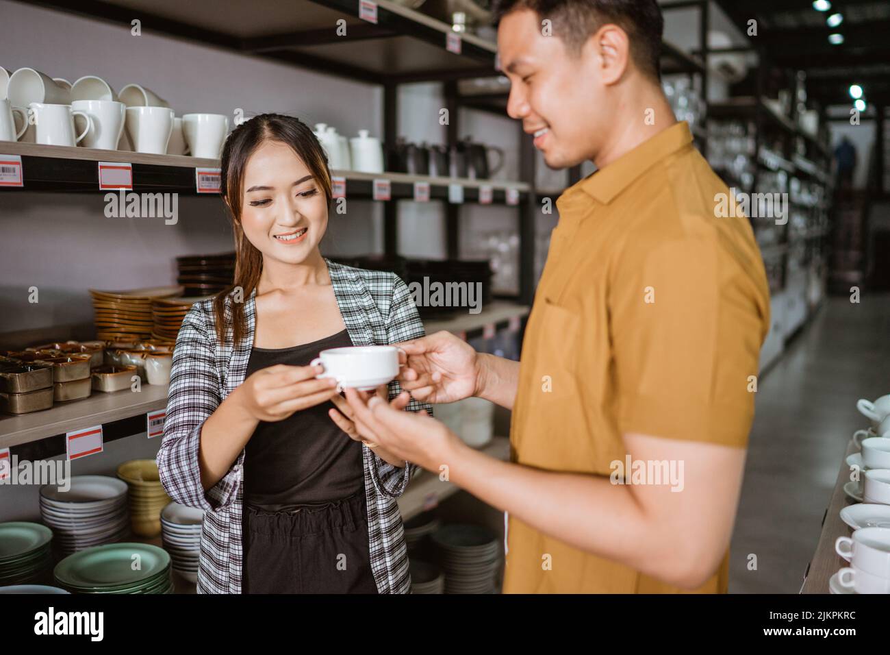 Beautiful girl and her boyfriend holding cups while choosing cups Stock ...