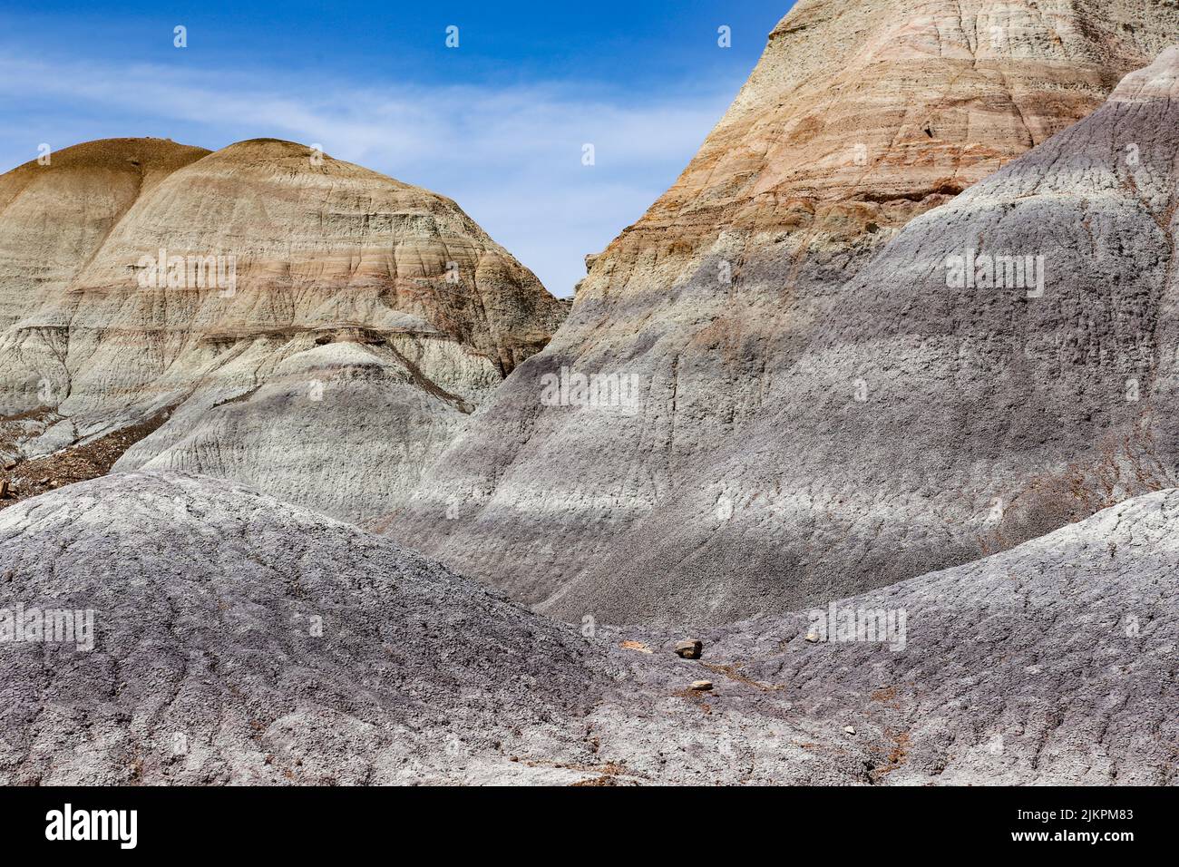 Dry striped rough rock formations in a desert against a blue sky Stock ...