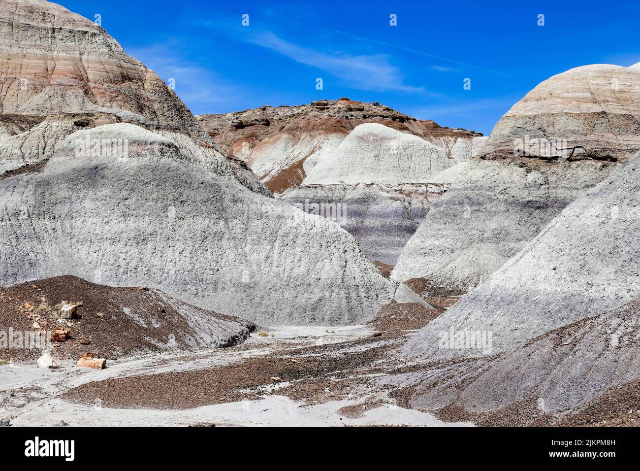 A dry landscape of striped rock formations in a desert under the ...