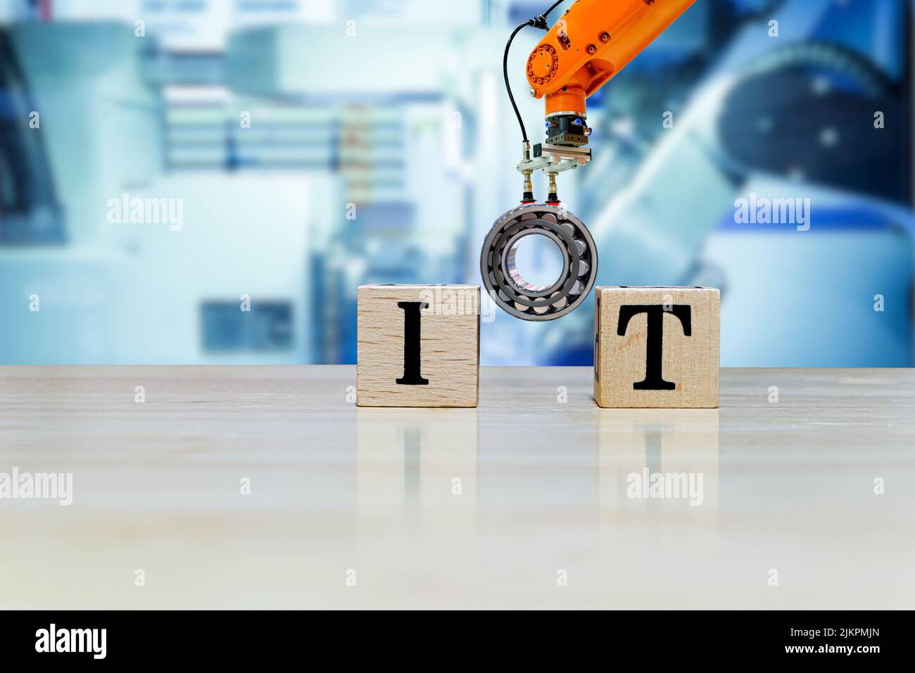 Industrial griping robot picking metal part for build message on wooden ...