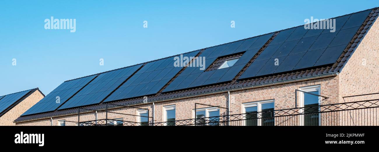 Newly build houses with solar panels attached on the roof against a ...