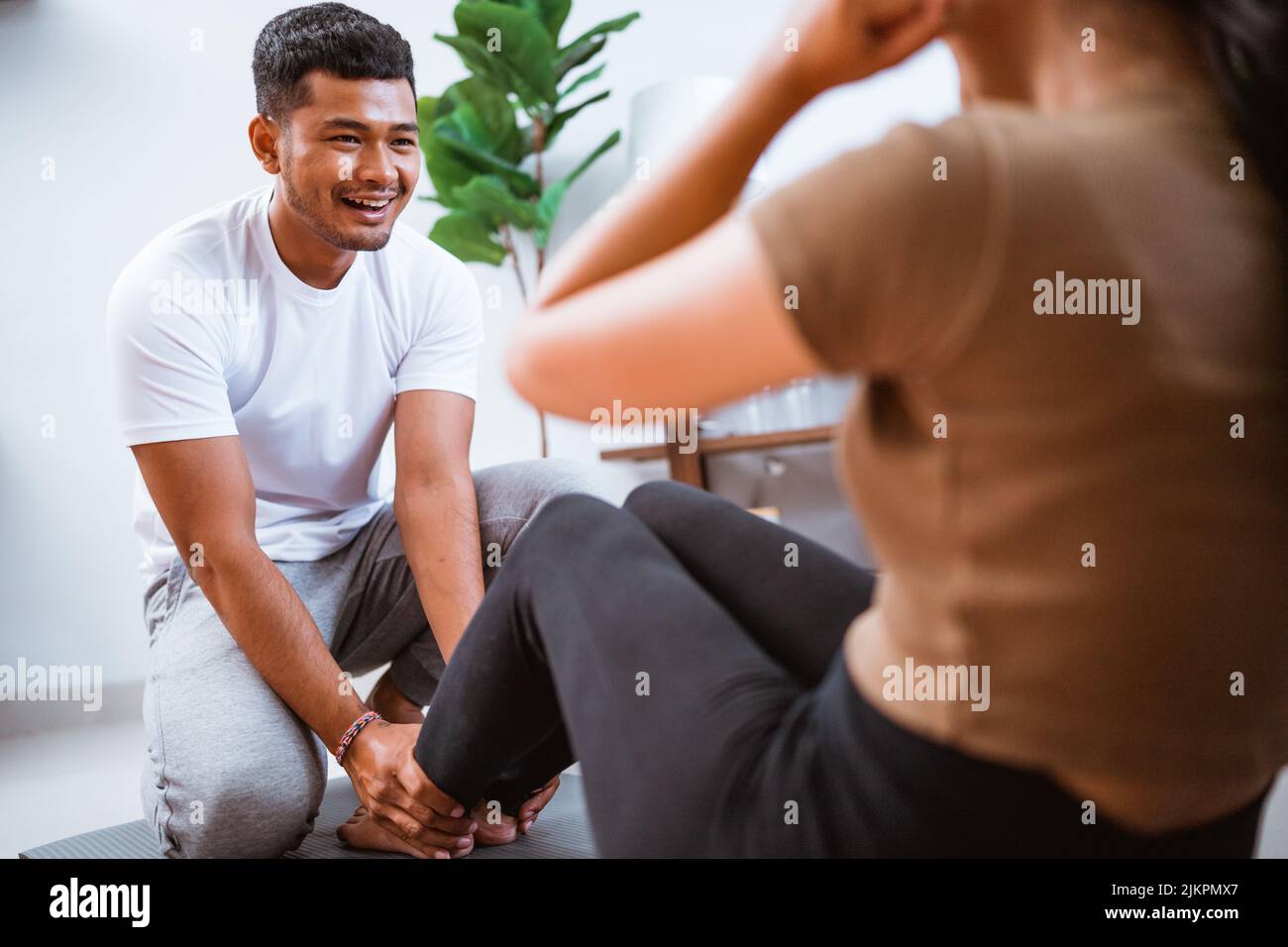 beautiful young couple doing exercise together at home Stock Photo - Alamy
