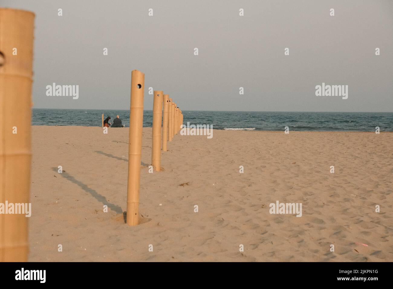 The wooden poles with holes for a rope on the beach Stock Photo - Alamy