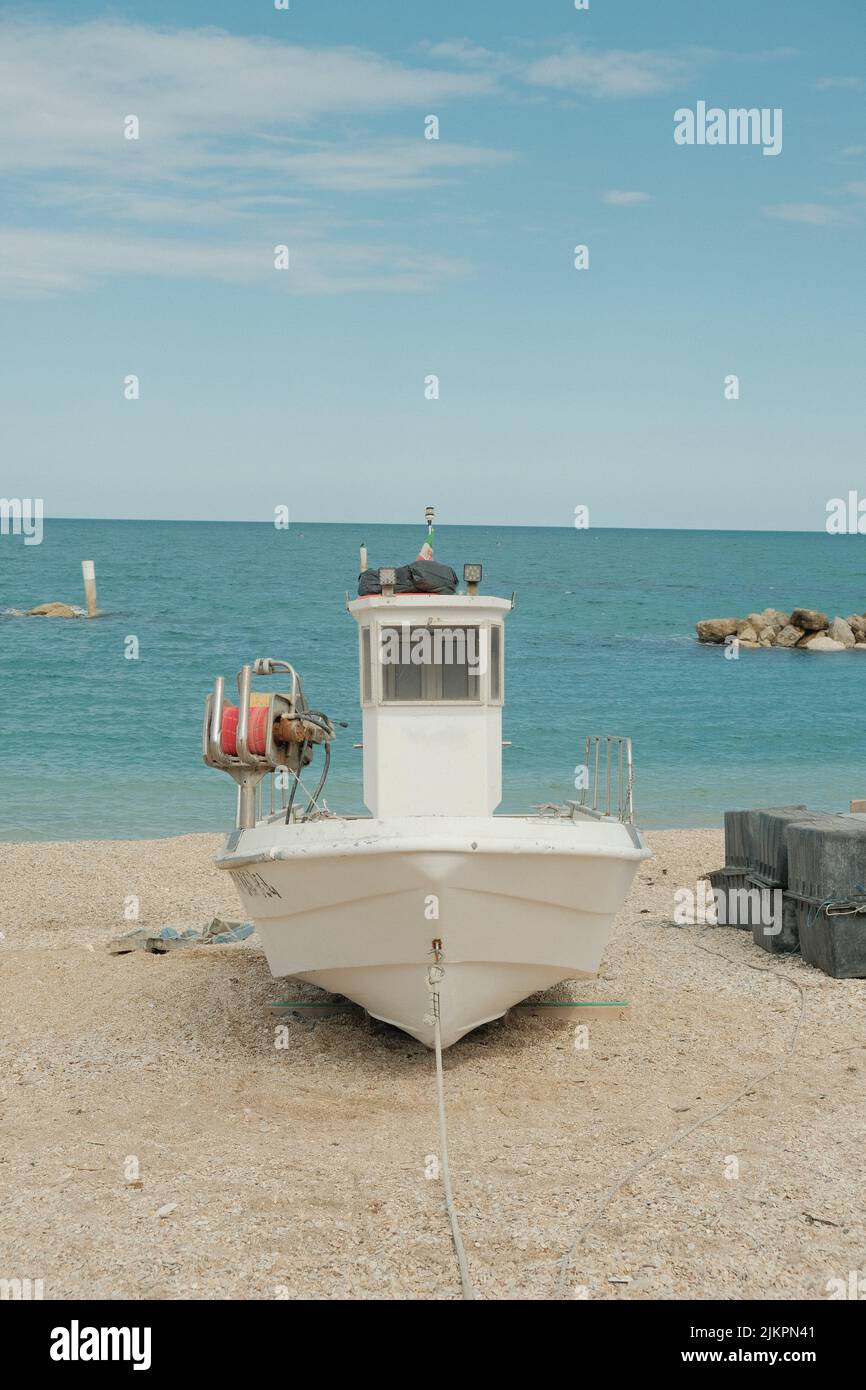 A vertical shot of a white boat on the beach Stock Photo - Alamy