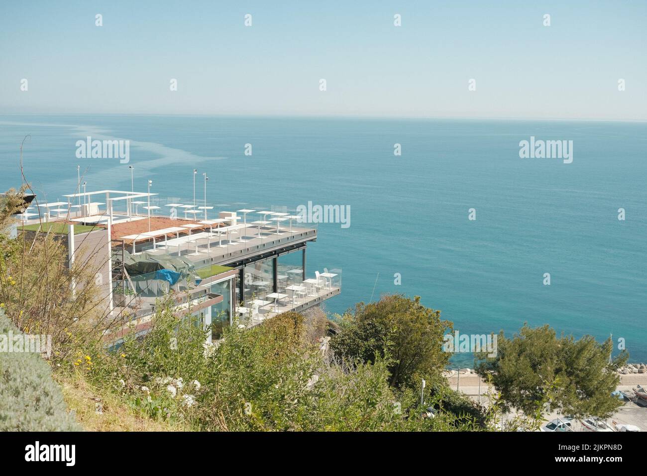 An outdoor cafe with white tables overlooking the sea Stock Photo - Alamy