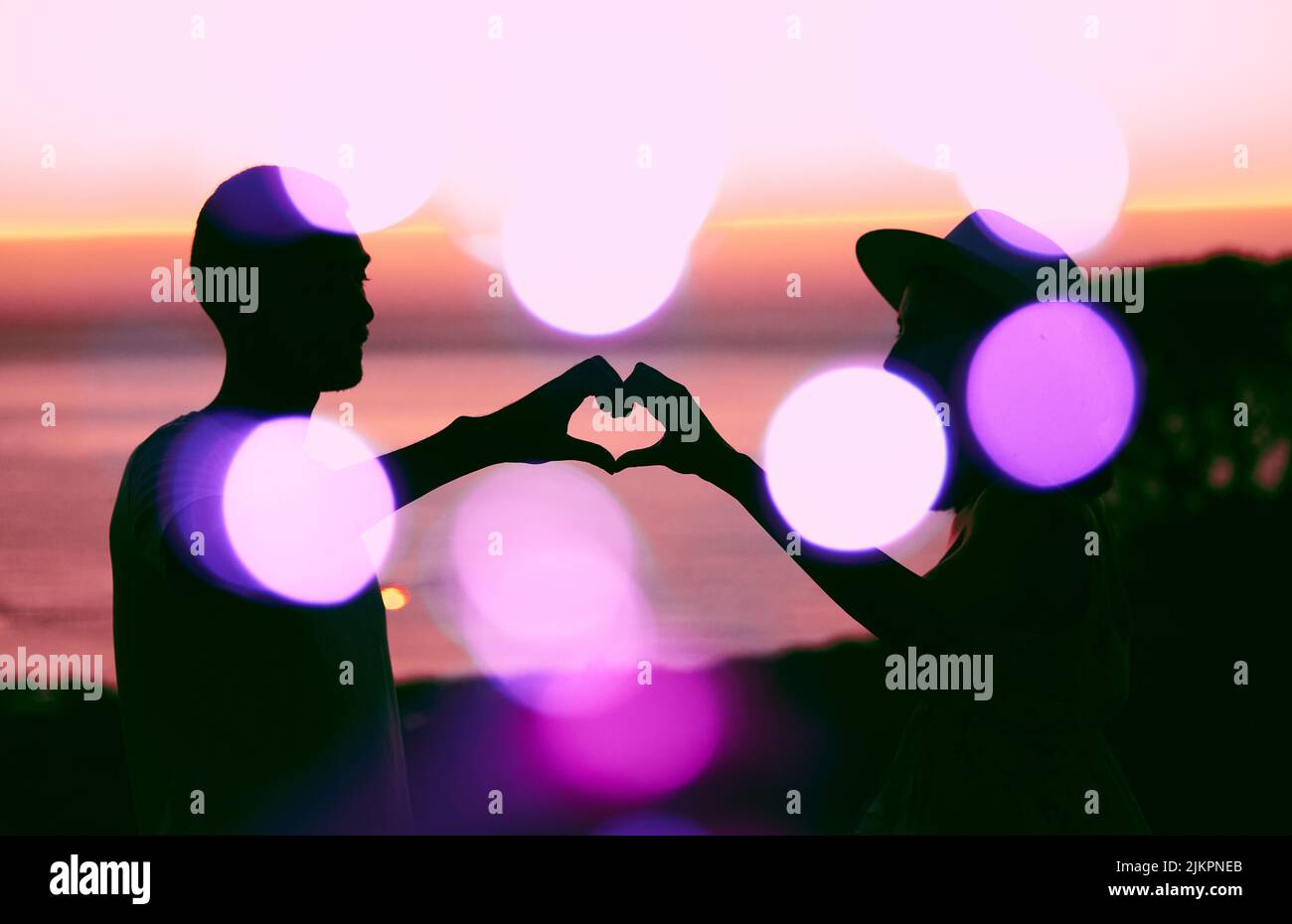 Two hearts become one. an affectionate young couple silhouetted at ...