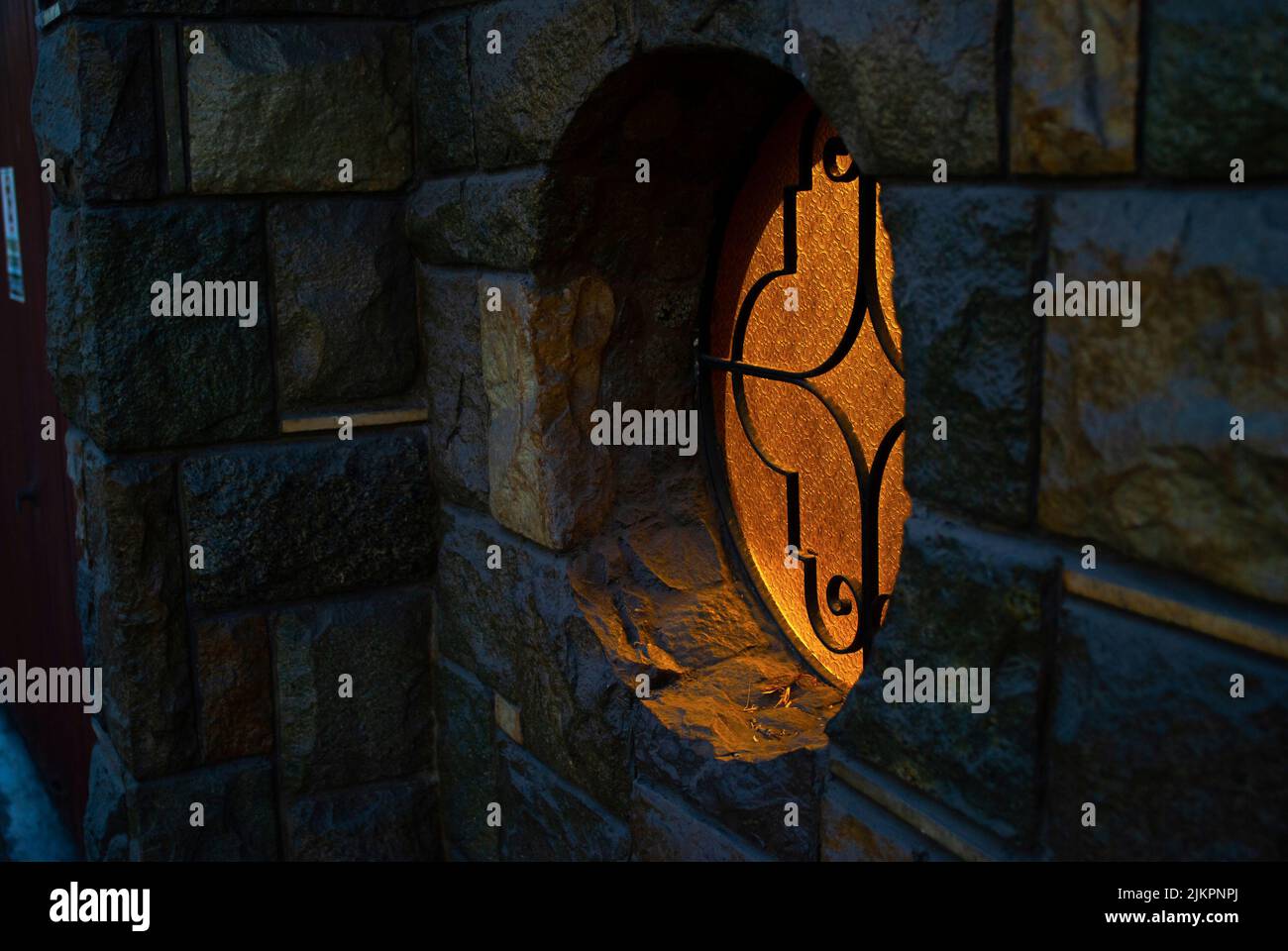 A view of a beautiful ornamented round window on a wall of a brick ...