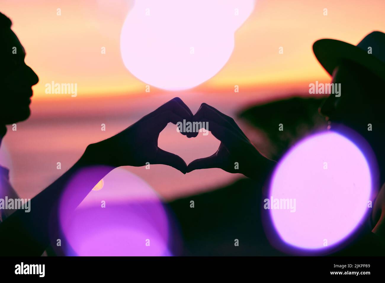 It takes two to fall in love. an affectionate young couple silhouetted ...