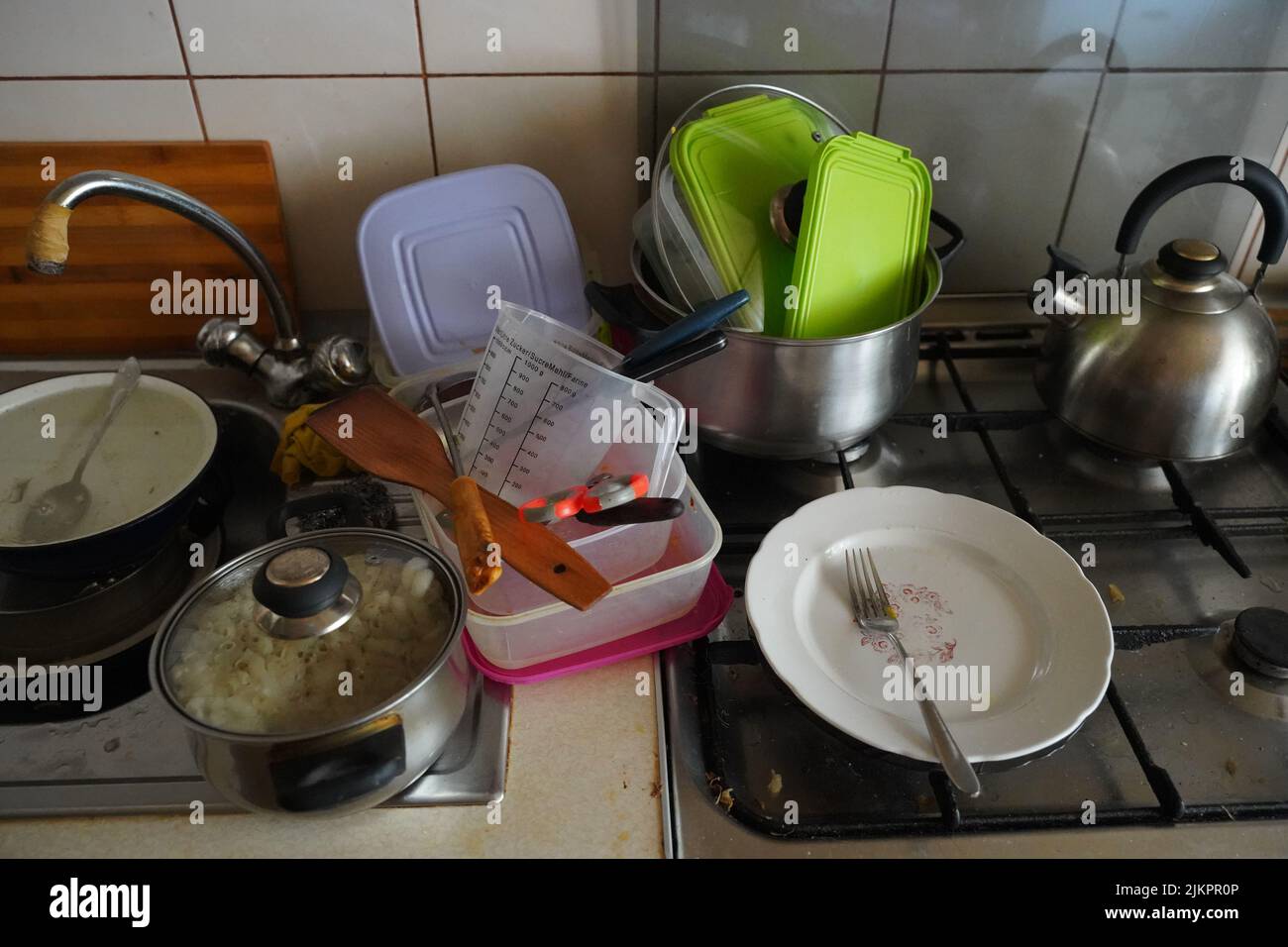 Dirty dishes in the kitchen and stove. Unwashed spoons, forks, pots ...