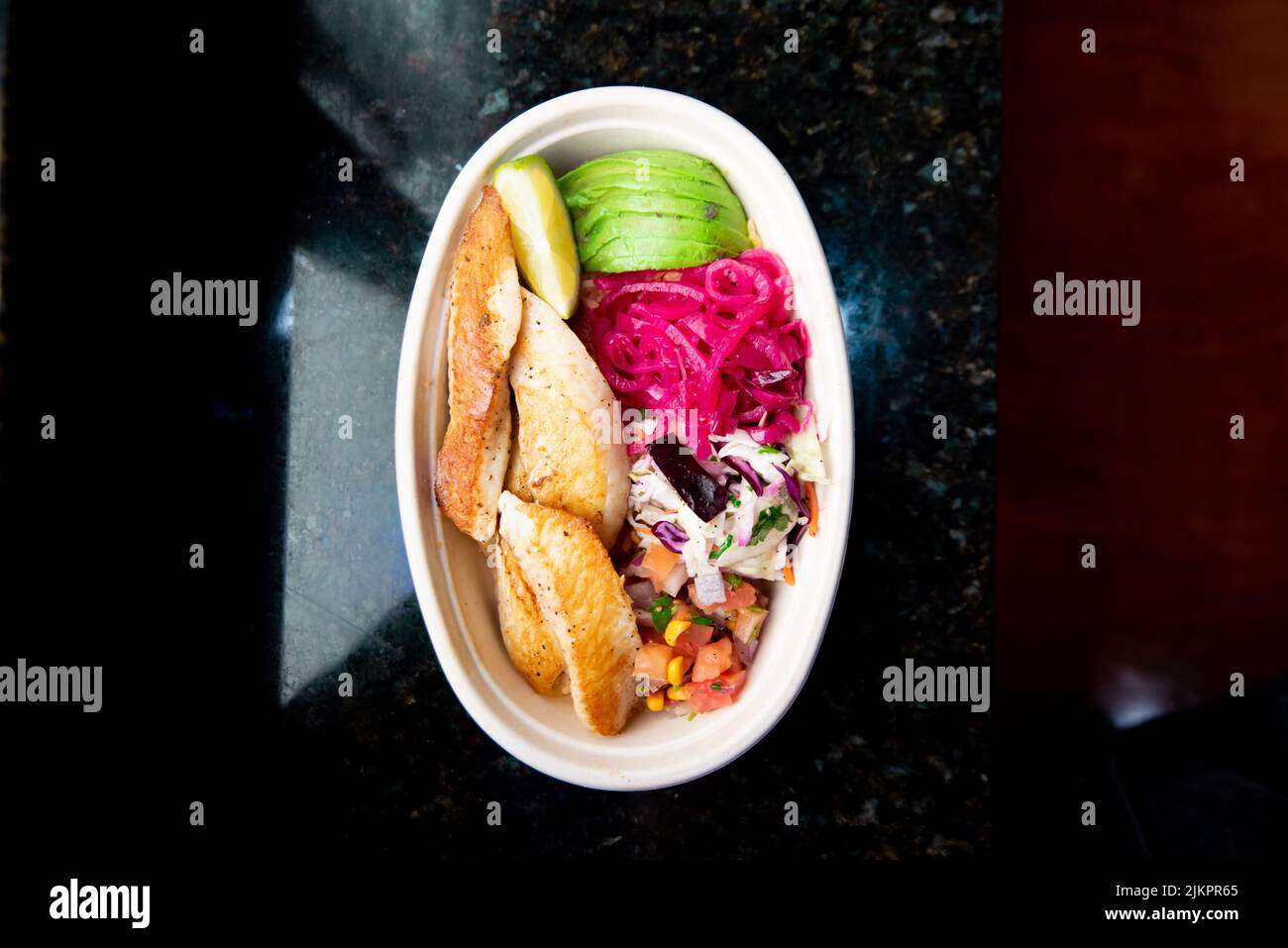 A top view of a Mexican fishbowl with guacamole, radish, rice, and ...