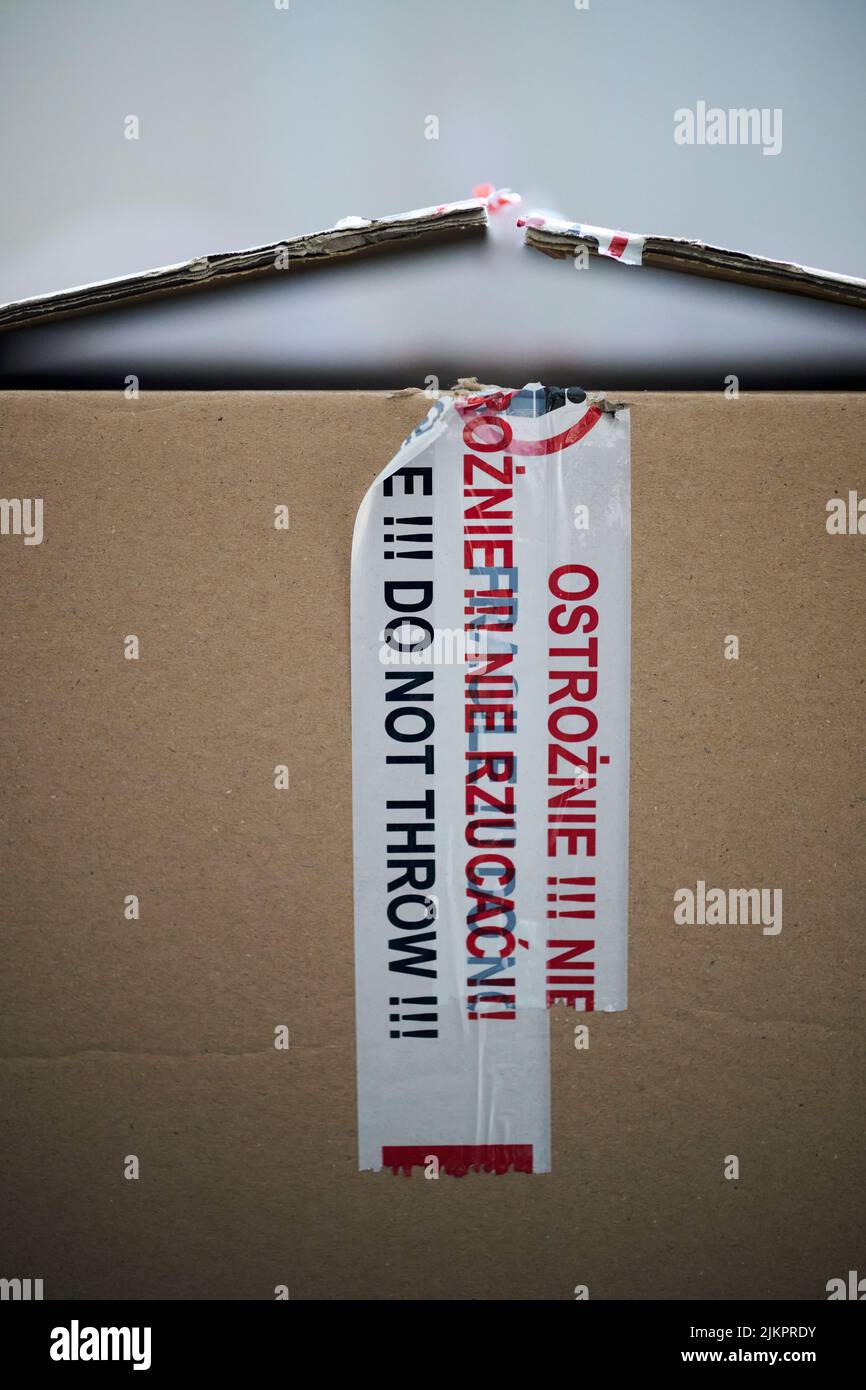 A vertical closeup of a delivery box with a no-drop warning sticker ...
