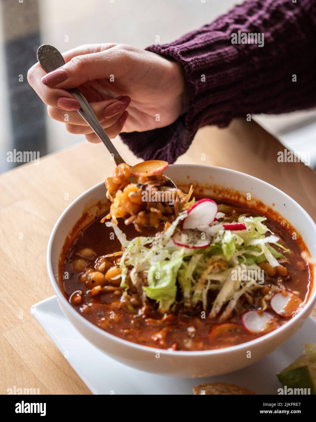 A vertical closeup shot of a person eating a freshly served Mexican ...