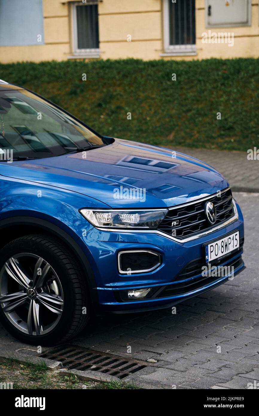 A vertical shot of the front part of a parked blue new Volkswagen car ...