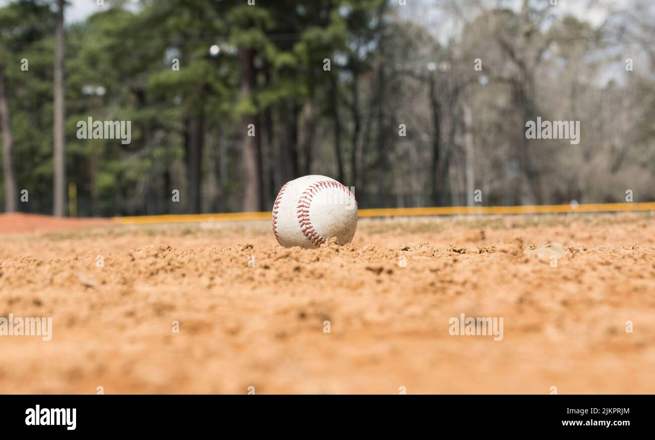 A baseball sits on a field ready to be picked up and used in a game of ...