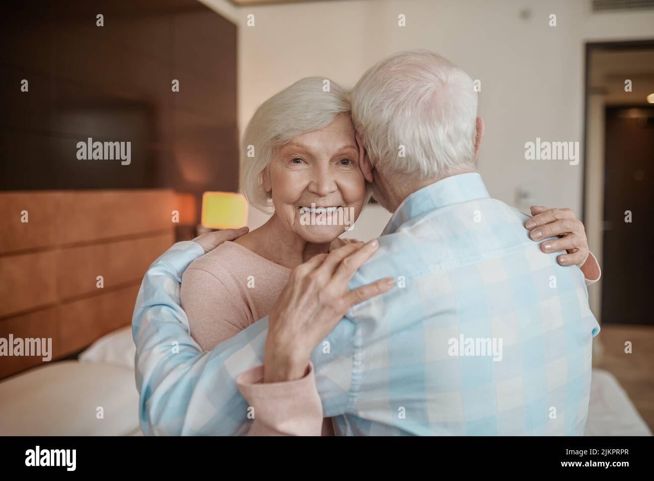 Gray-haired couple embracing and feeling happy Stock Photo - Alamy
