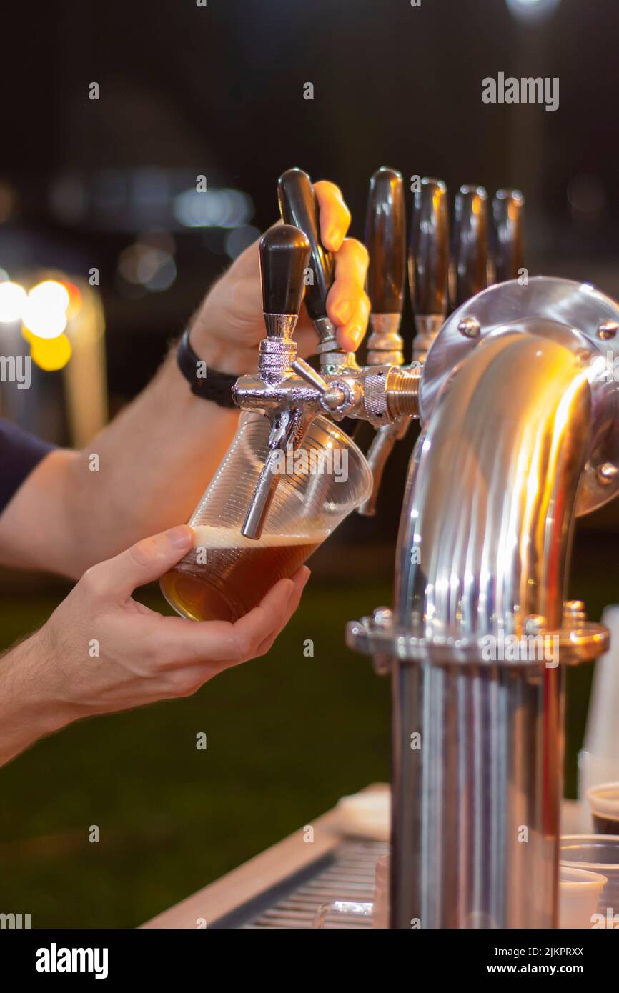 A male's hands pouring beer in a plastic cup from a kegerator Stock ...