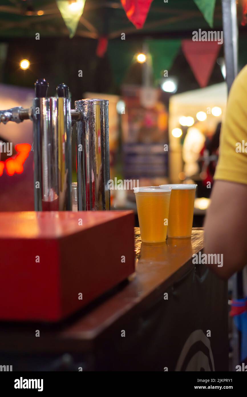 A serving of fresh beer in a plastic cup on a counter Stock Photo - Alamy