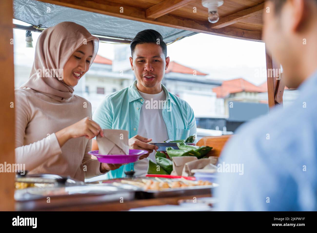 couple picking some snack and food at traditional street food stall ...