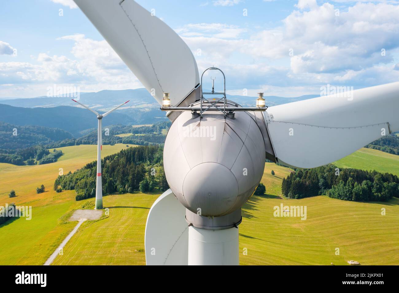 Close up a propeller of the windmill in the yellow field with mountains ...