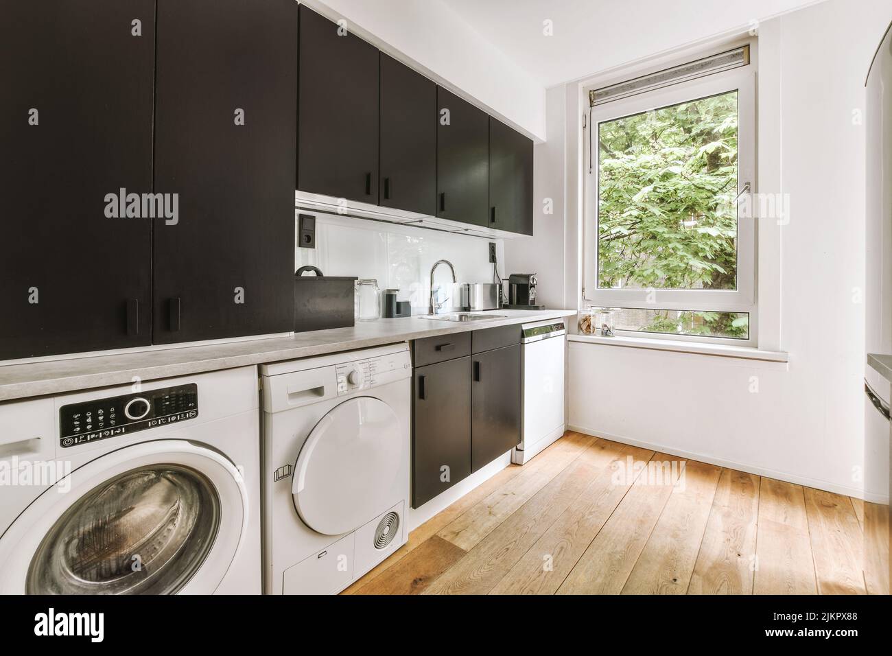 Interior of modern bright laundry room with white walls and dark ...