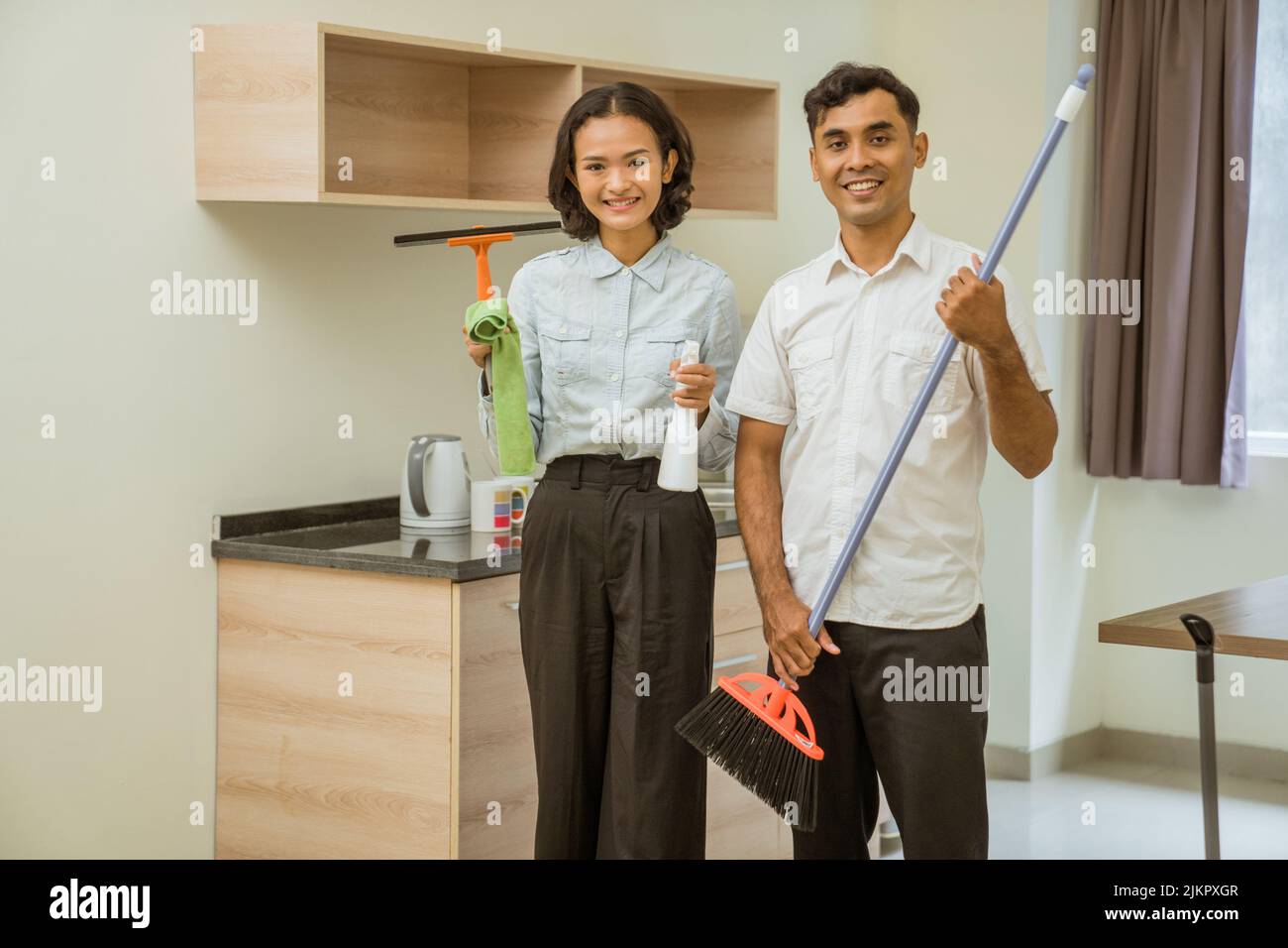 female and male housemaid holding wiper, cloth, sprayer and broom Stock ...