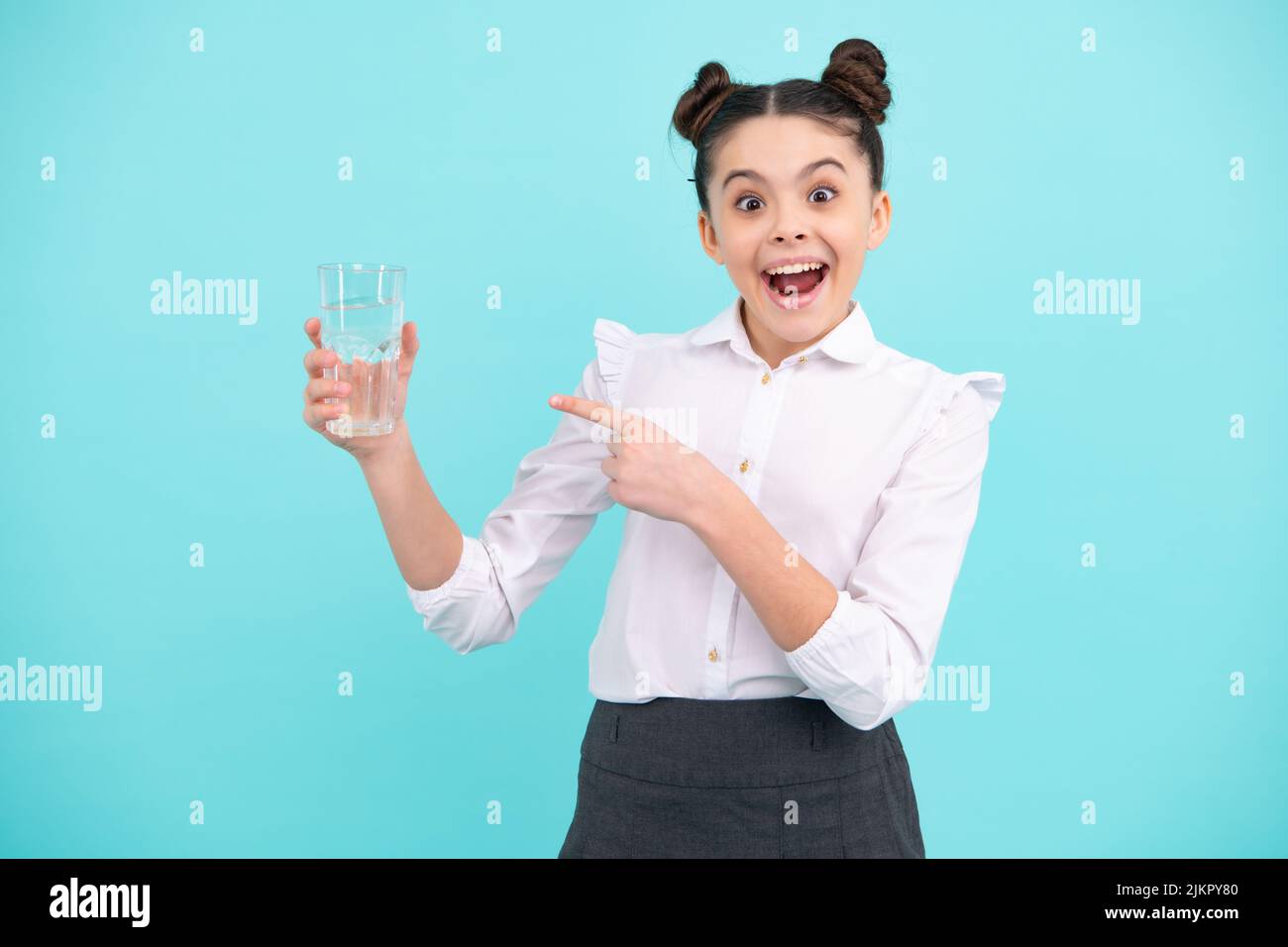 Teenager girl drinking water from glass on blue background. Daily life ...