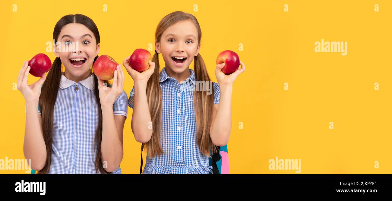 Eat fruit to be cute. Happy school friends hold apples. Healthy eating ...