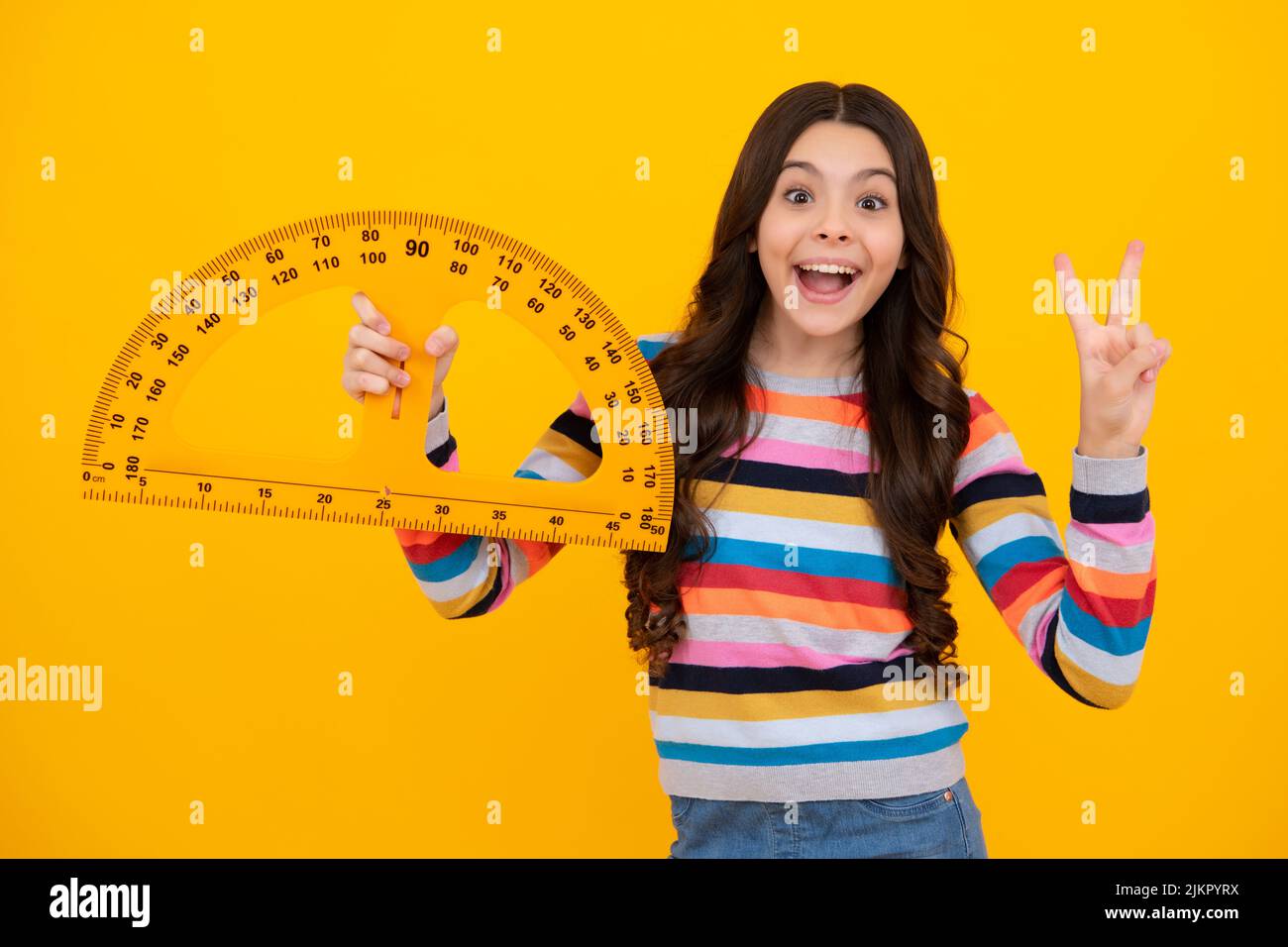 Amazed teenager. Schoolgirl in school uniform hold mathematics measure ...