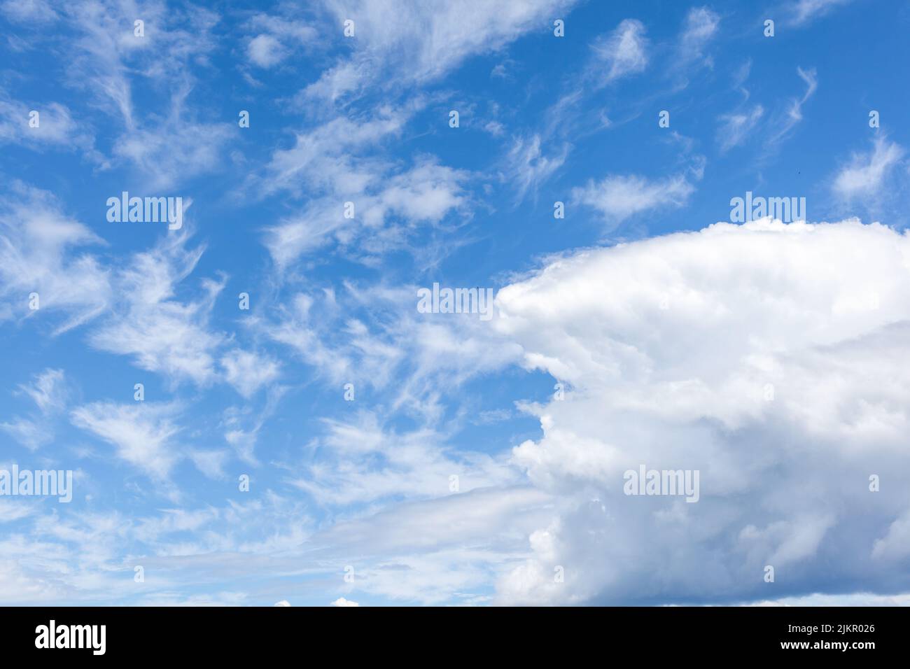 Big white clouds in a blue sky close-up. There is a place for the text ...