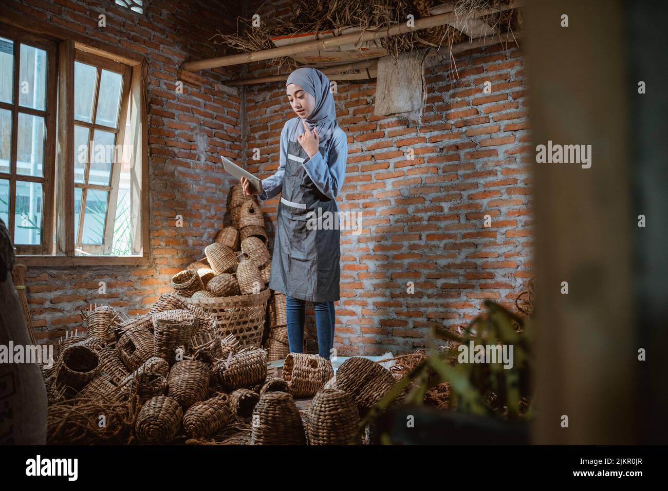 craftswoman in veil checking water hyacinth woven crafts Stock Photo ...