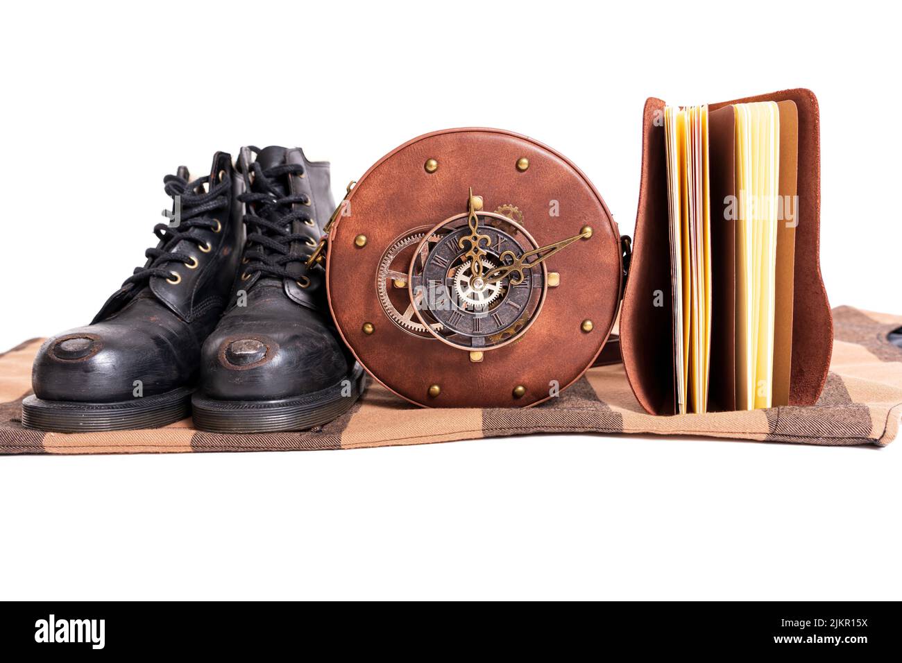 Work boots, circle leather clockwork bag and journal placed on a ...