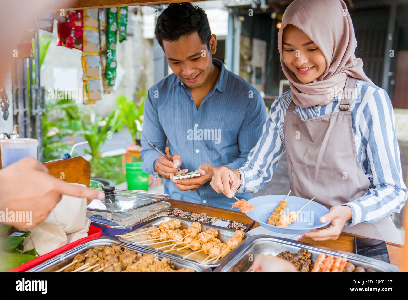 muslim couple ordering food to break fasting in ramadan Stock Photo - Alamy