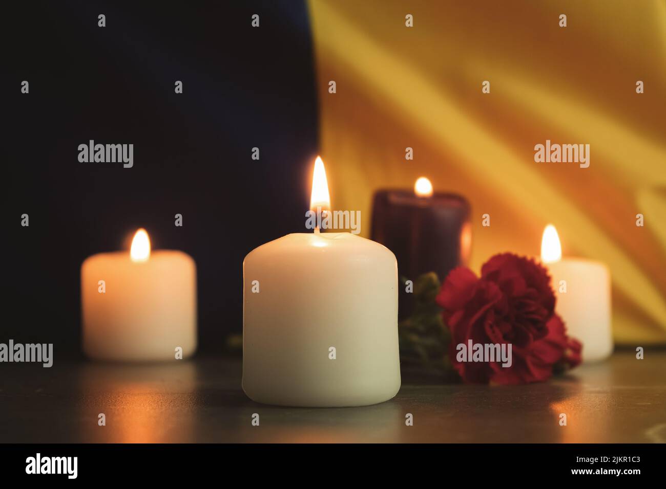 A group of burning candles and flowers on the background of the ...
