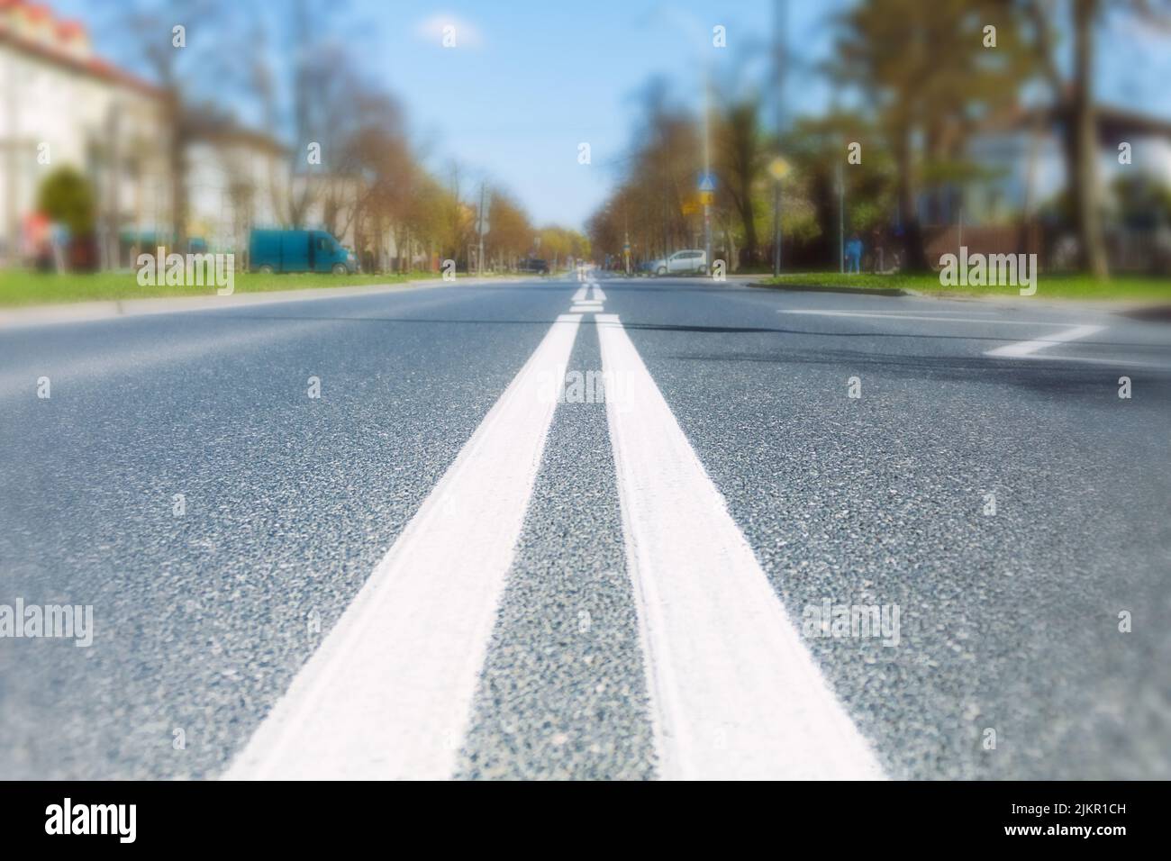 A road going into the distance in the autumn city. Clean gray asphalt ...