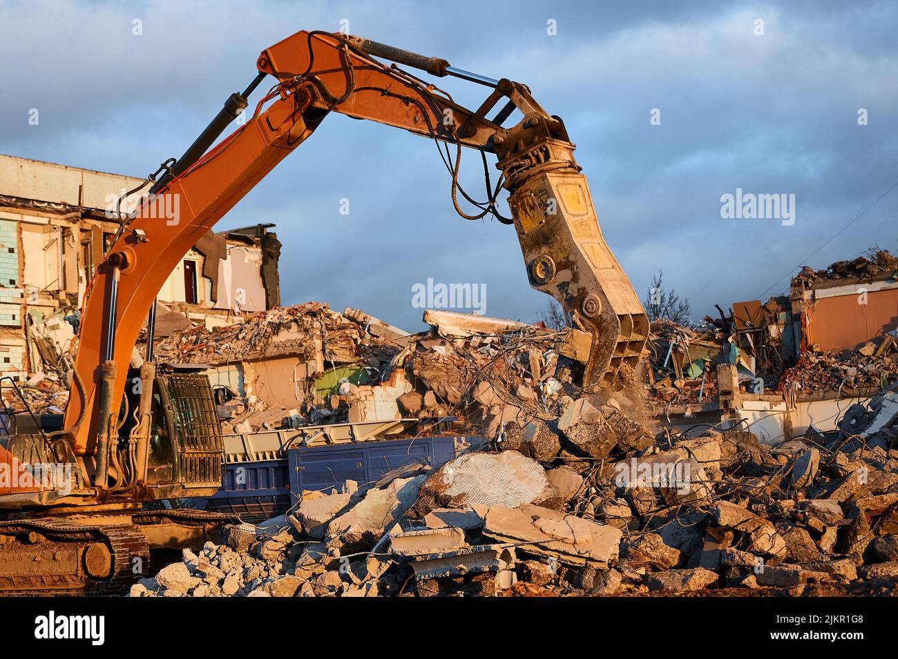 Crusher destroys reinforced concrete at demolition site Stock Photo - Alamy
